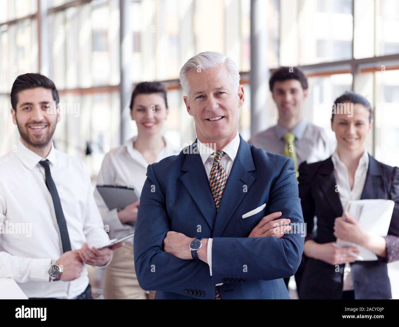 portrait of senior Businessman as leader with staff in background Stock ...