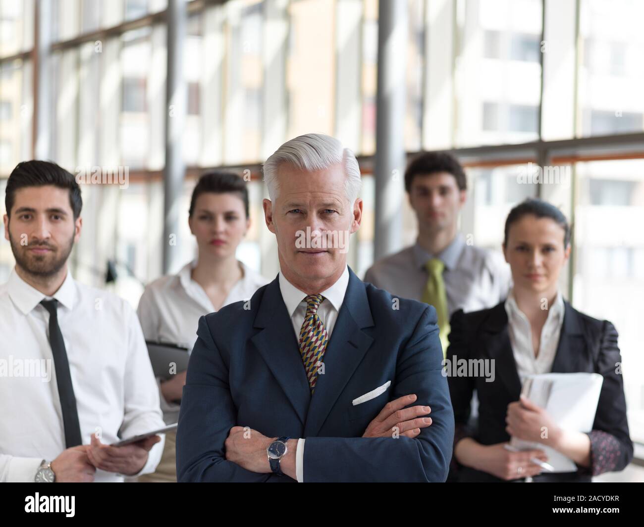portrait of senior Businessman as leader with staff in background Stock ...