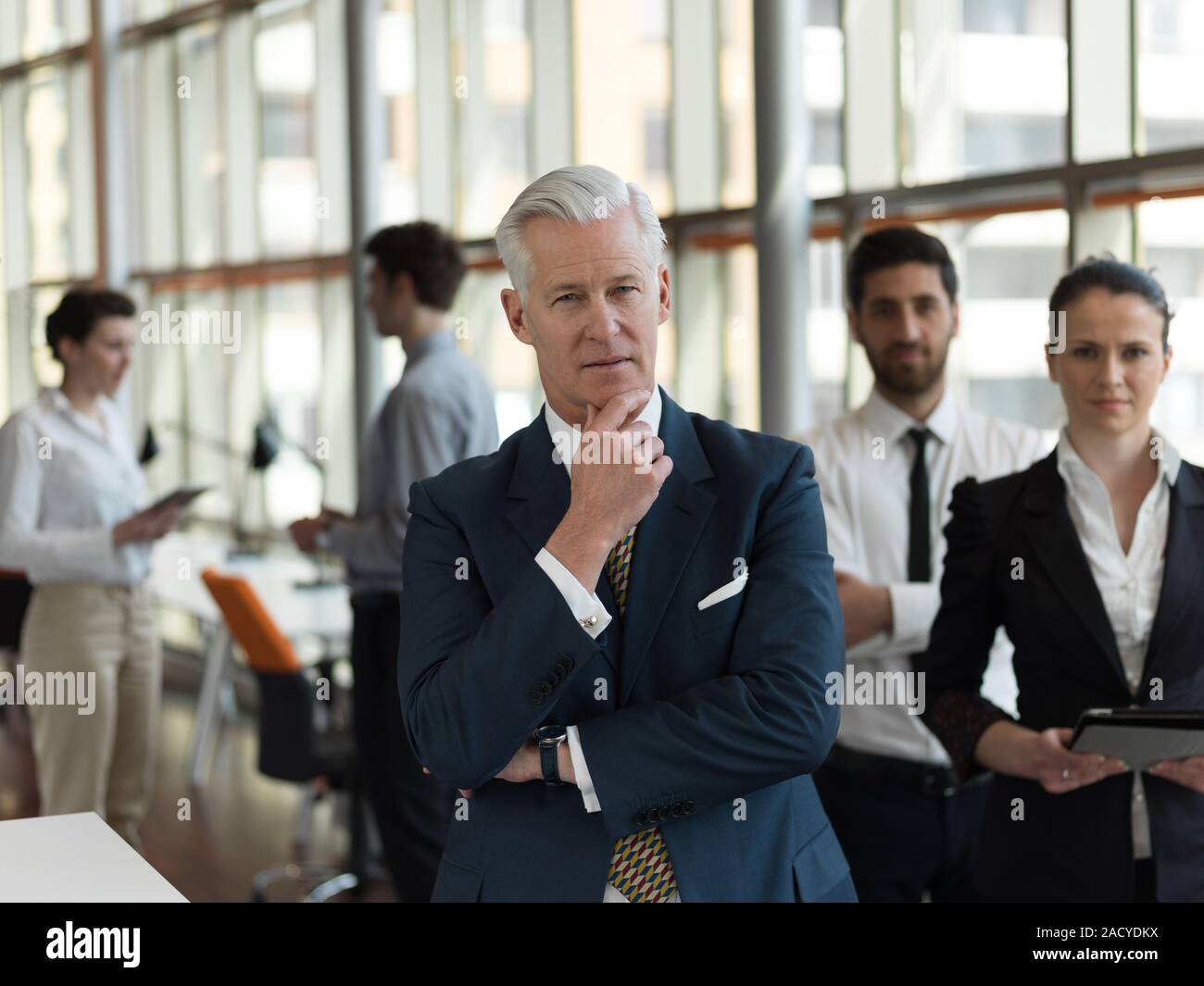 portrait of senior Businessman as leader with staff in background Stock ...