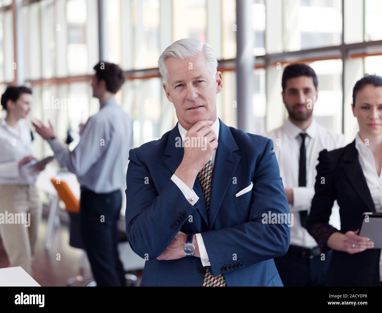 portrait of senior Businessman as leader with staff in background Stock ...