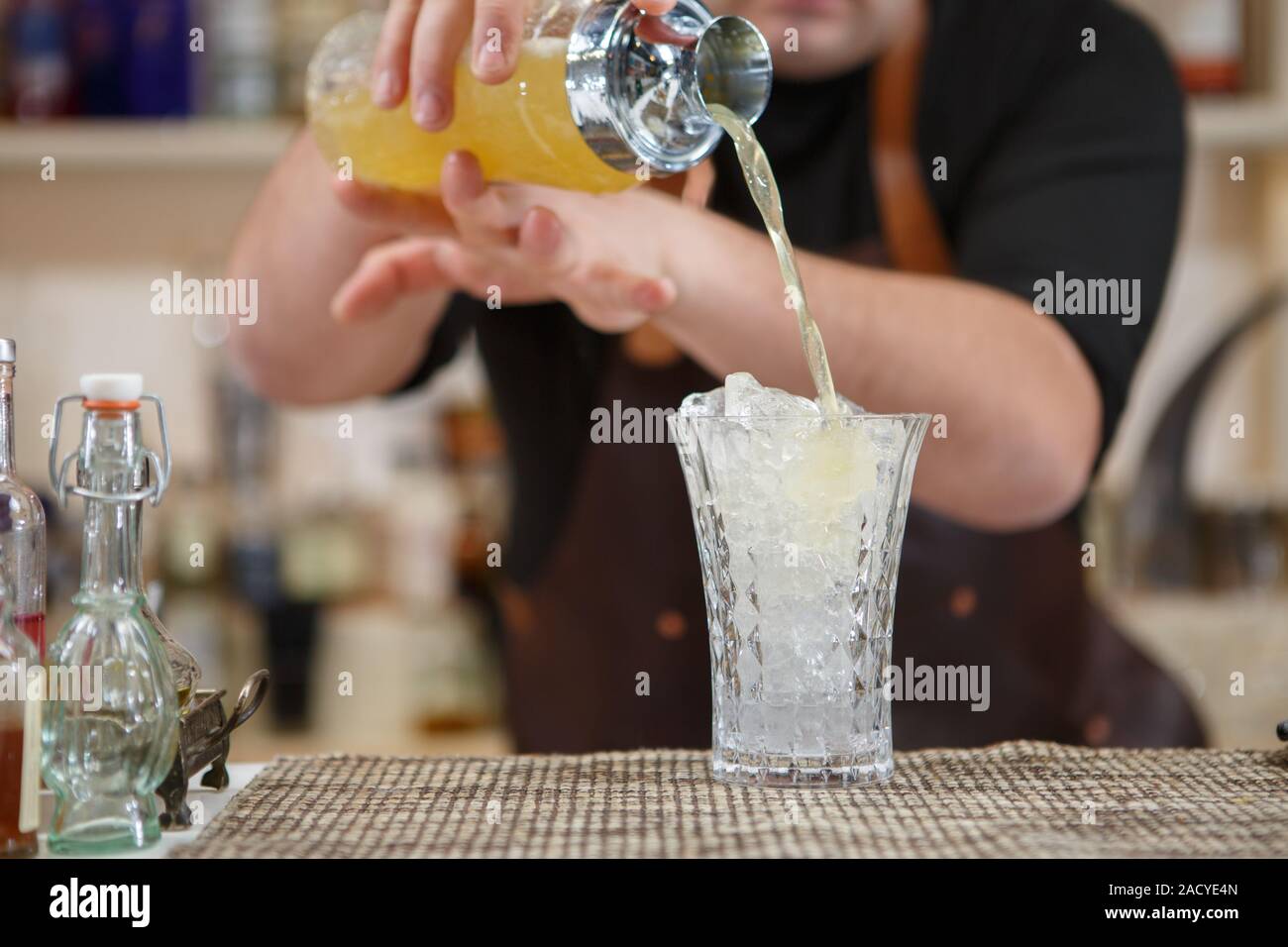 Bartender pouring cocktail into glass at the bar Stock Photo - Alamy