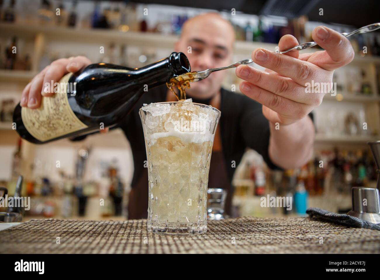 Bartender pouring cocktail into glass at the bar Stock Photo - Alamy