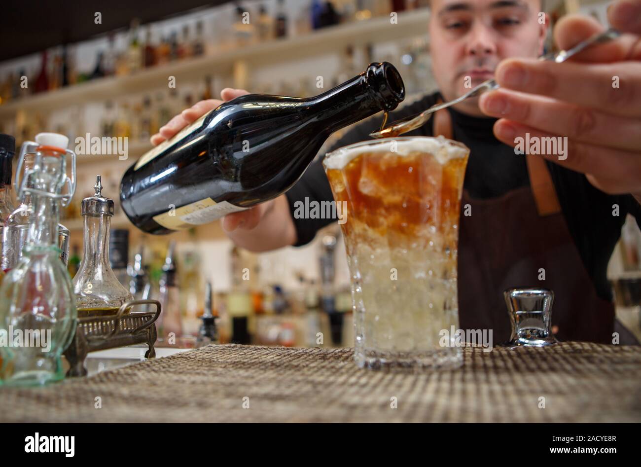 Bartender pouring cocktail into glass at the bar Stock Photo - Alamy