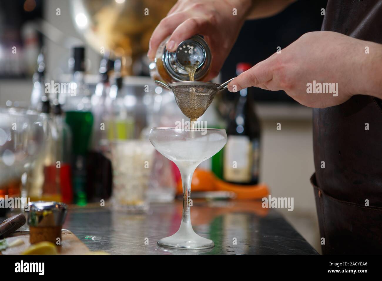 Bartender coocks cocktail behind a bar counter Stock Photo - Alamy