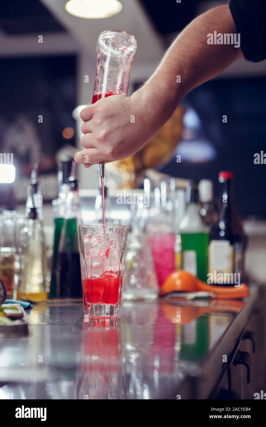 Bartender coocks cocktail behind a bar counter Stock Photo - Alamy