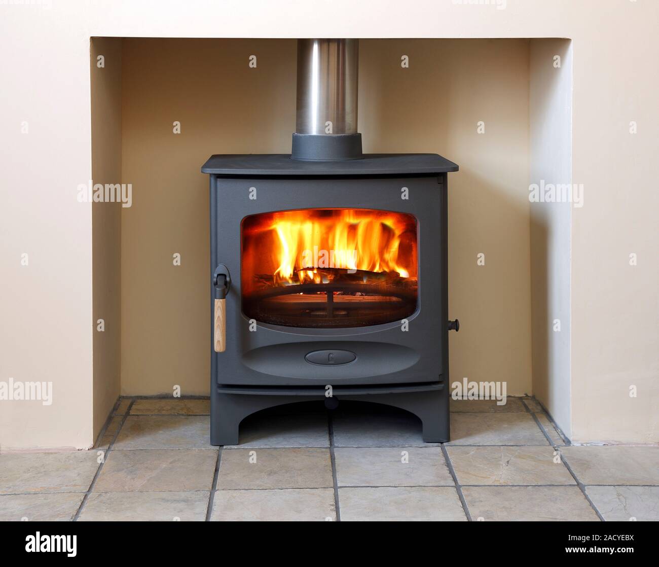 Wood-burning stove in a recess, with a pipe (flue) to remove combustion ...