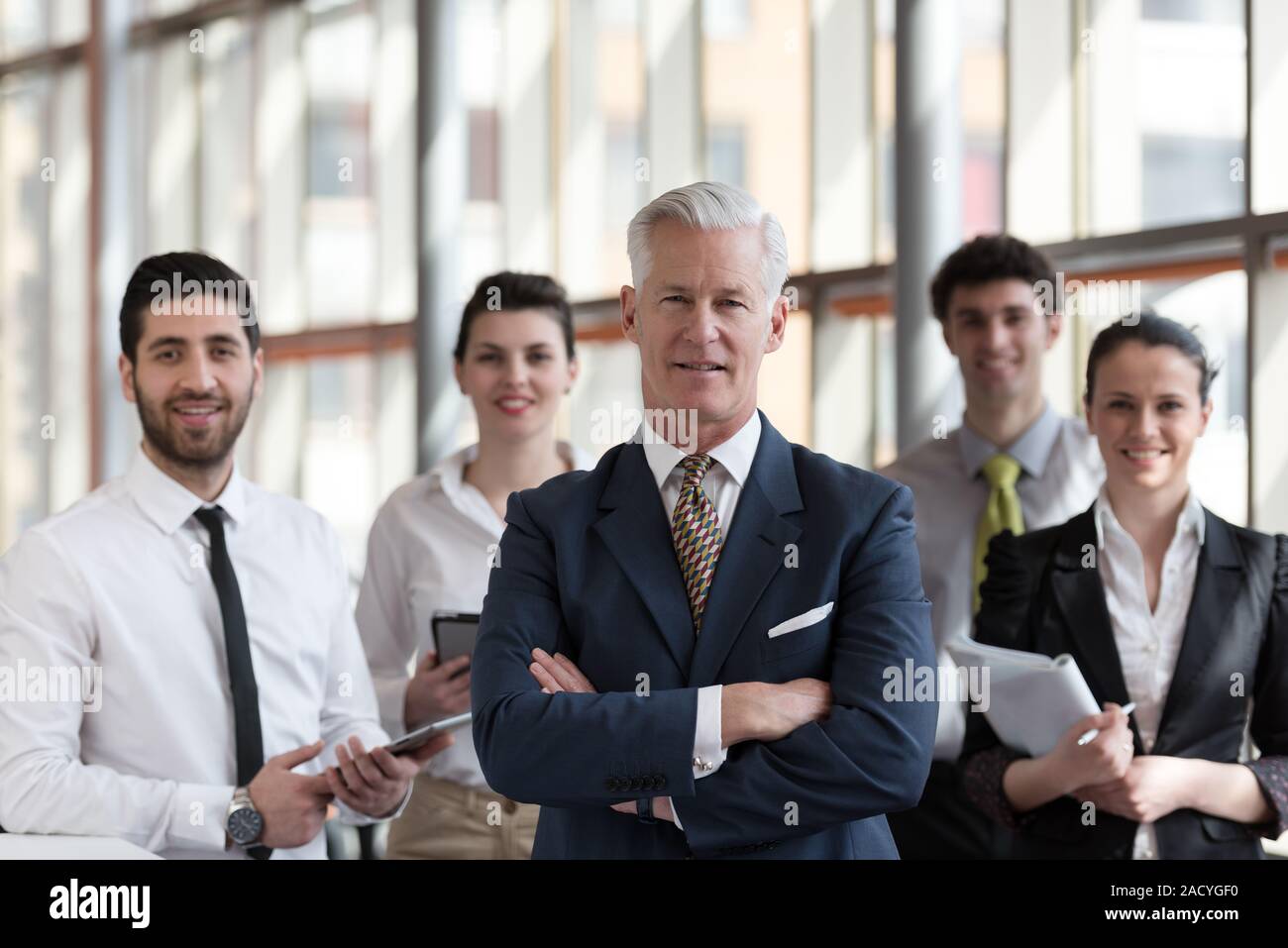 portrait of senior Businessman as leader with group of people in ...