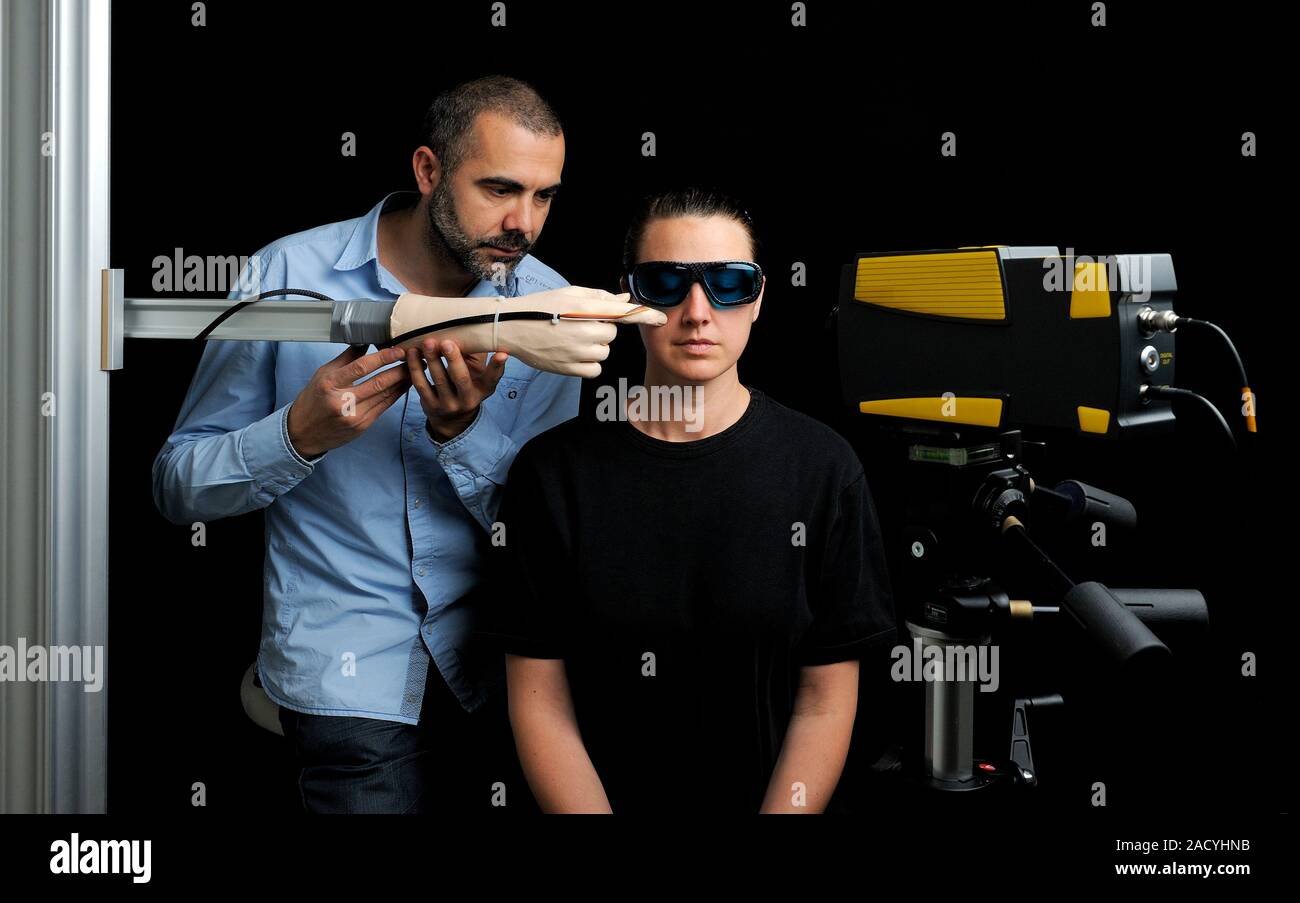 Measuring skin softness. Researcher using an artificial finger equipped ...