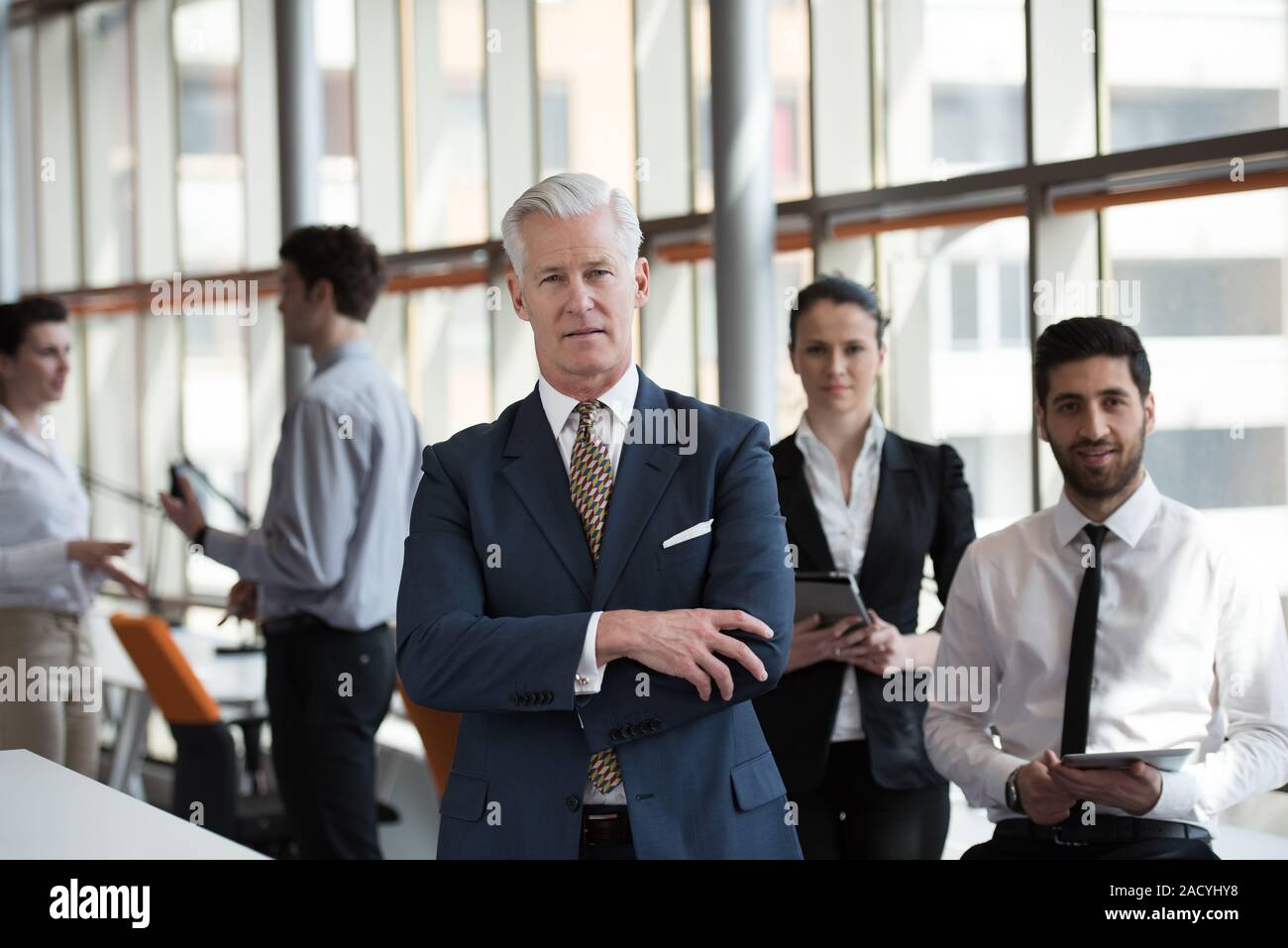 portrait of senior Businessman as leader with group of people in ...