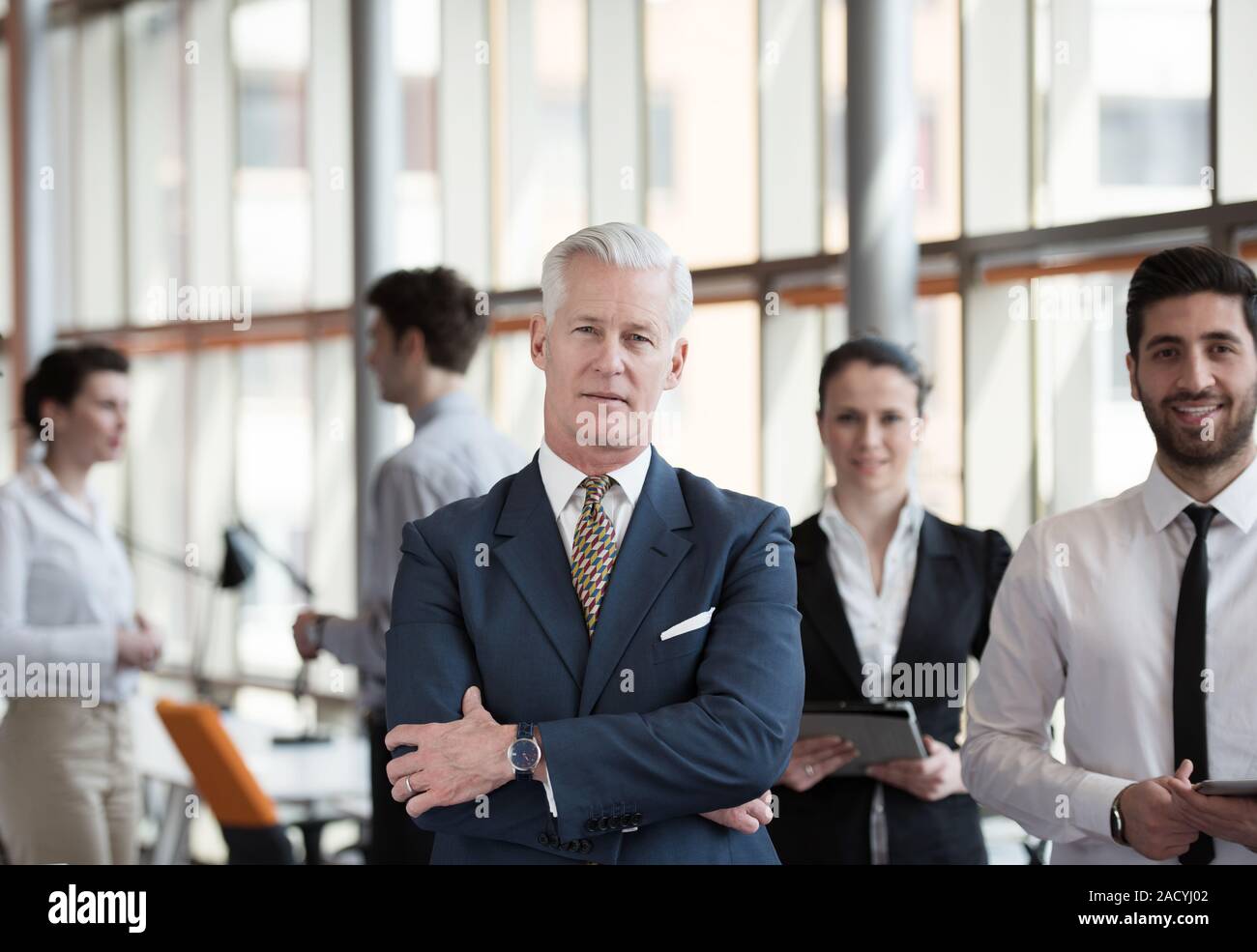 portrait of senior Businessman as leader with group of people in ...