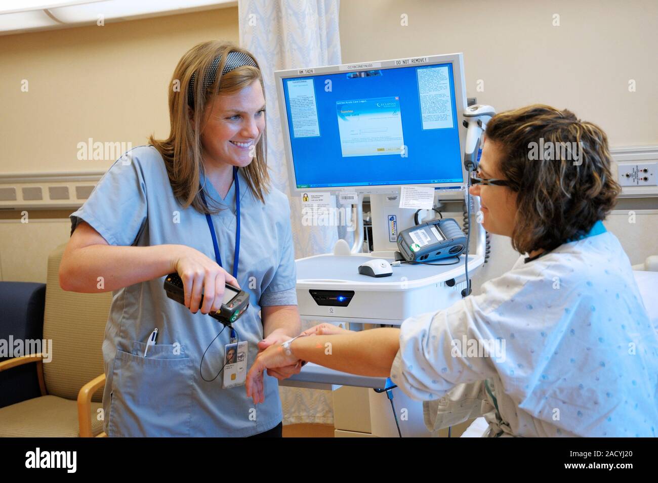 Electronic patient identification. Nurse using a scanner to ...