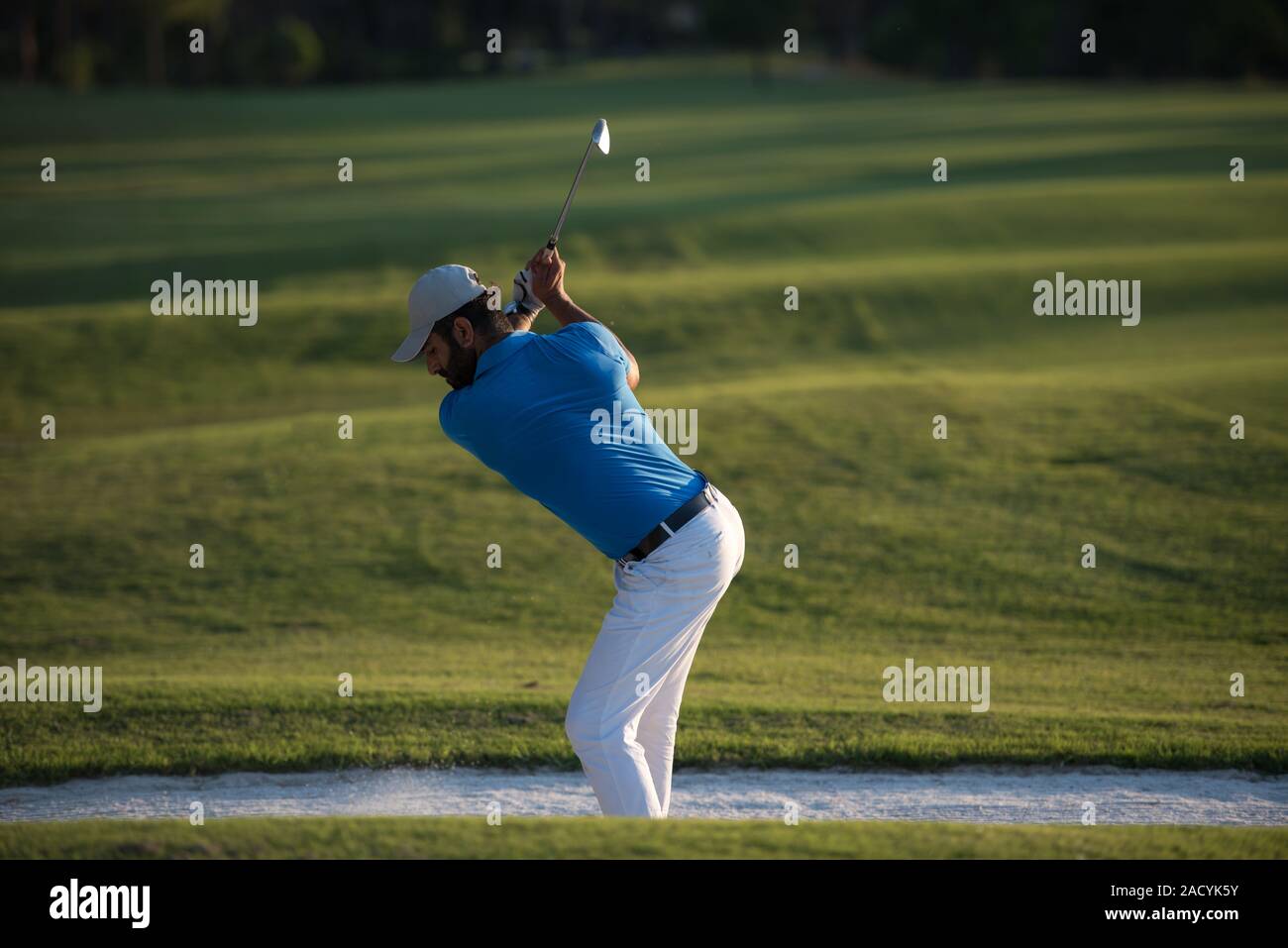 golfer hitting a sand bunker shot on sunset Stock Photo - Alamy