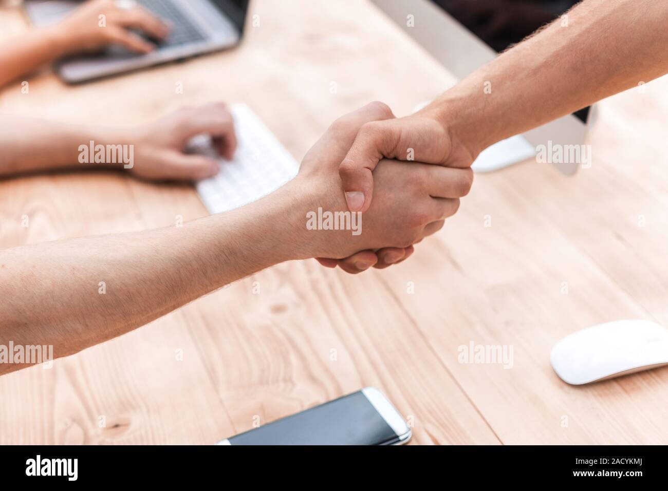 close up. employees shaking hands in the workplace Stock Photo - Alamy
