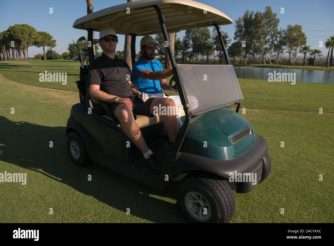 golf players driving cart at course Stock Photo - Alamy