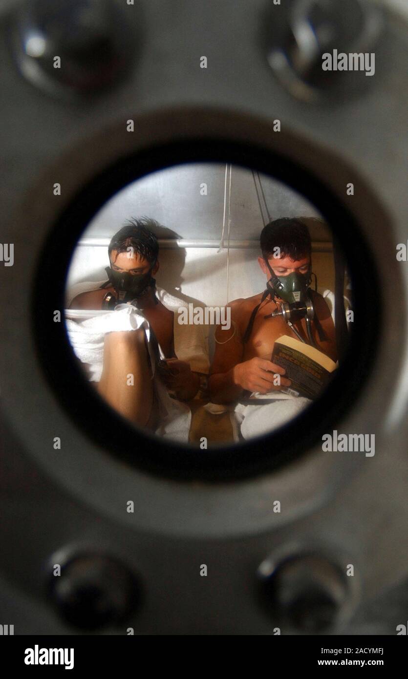 US Navy divers in a decompression chamber. US Navy divers breathing ...