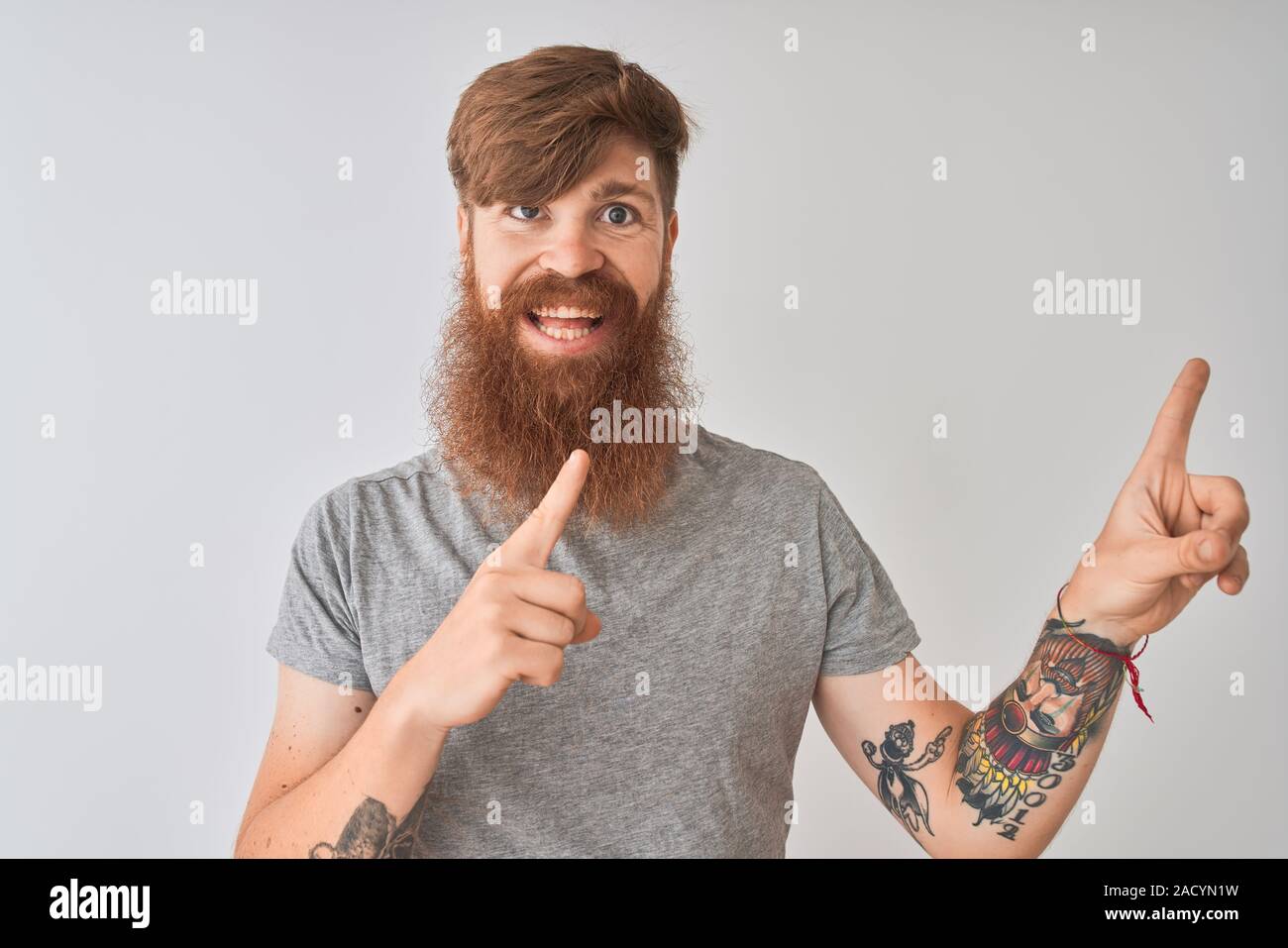 Young redhead irish man wearing t-shirt standing over isolated grey ...