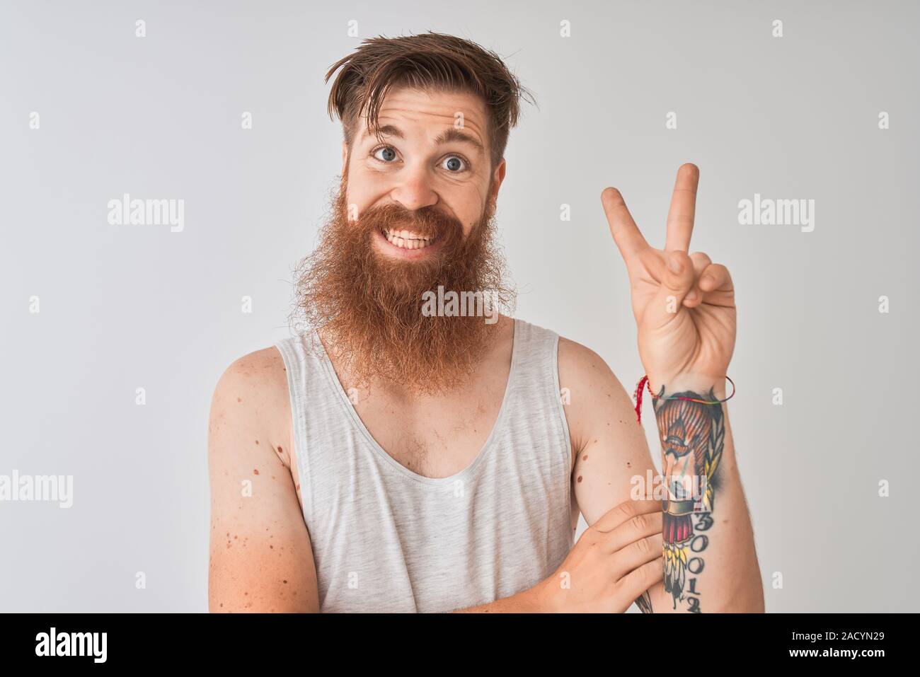 Young redhead irish man wearing t-shirt standing over isolated grey ...