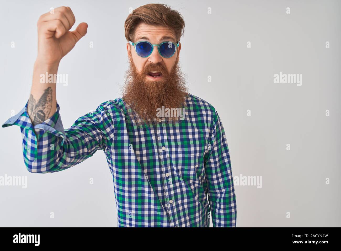 Young redhead irish man wearing casual shirt and sunglasses over ...