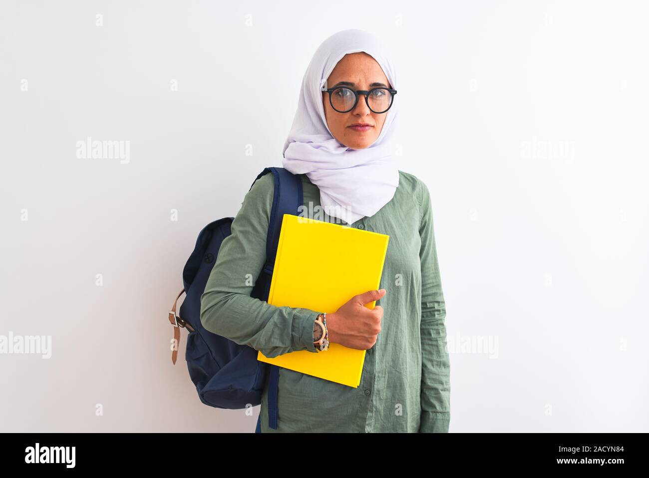 Young Arab student woman wearing hijab and backpack holding a book over ...