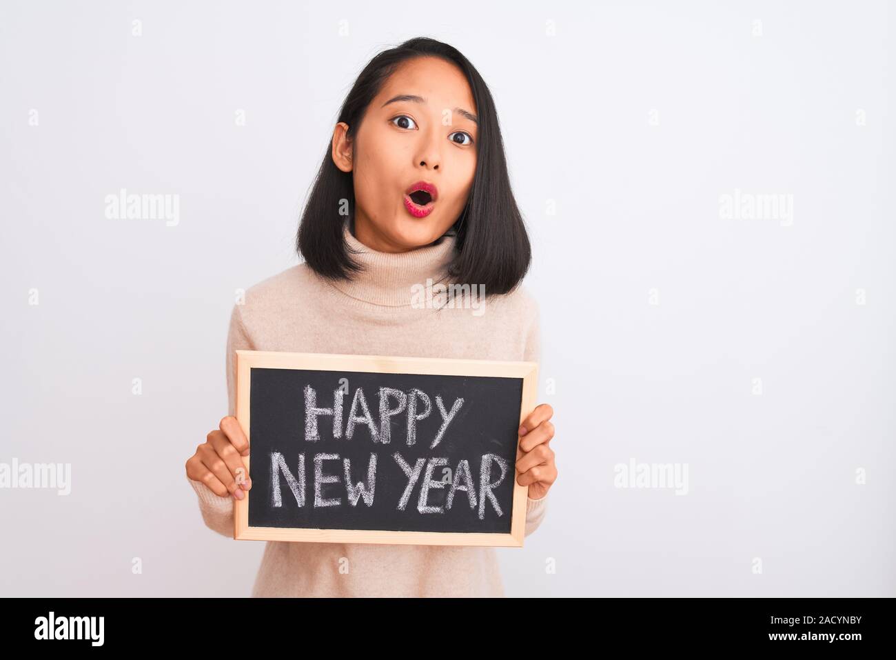 Young beautiful chinese woman holding blackboard over isolated white ...