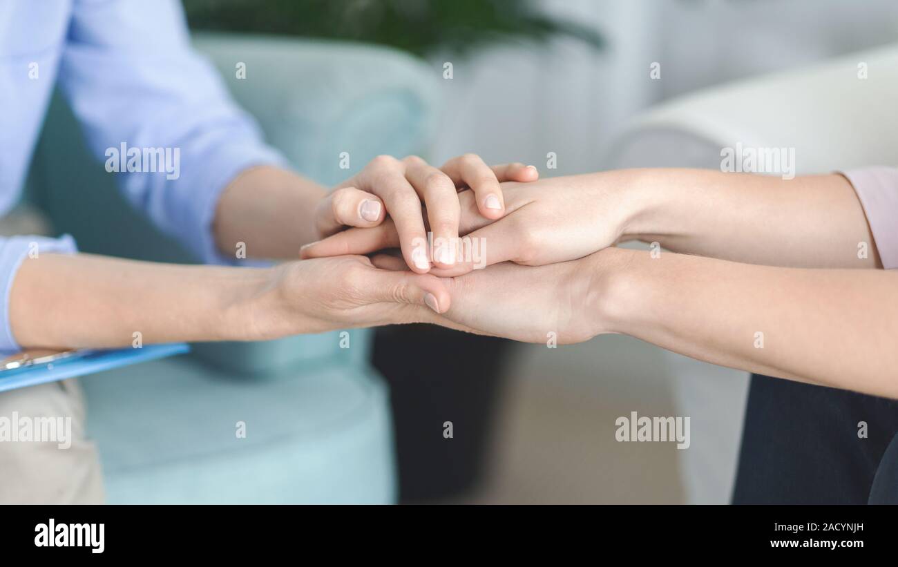 Psychologist consoling her client, holding her hands Stock Photo - Alamy