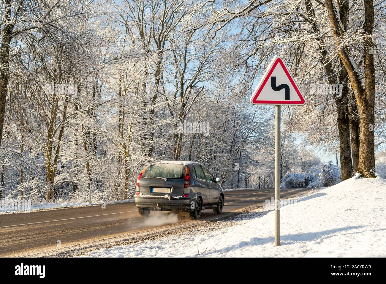 Winter Driving - Curvy Winter Road with Warning Sign. Snow-covered road ...