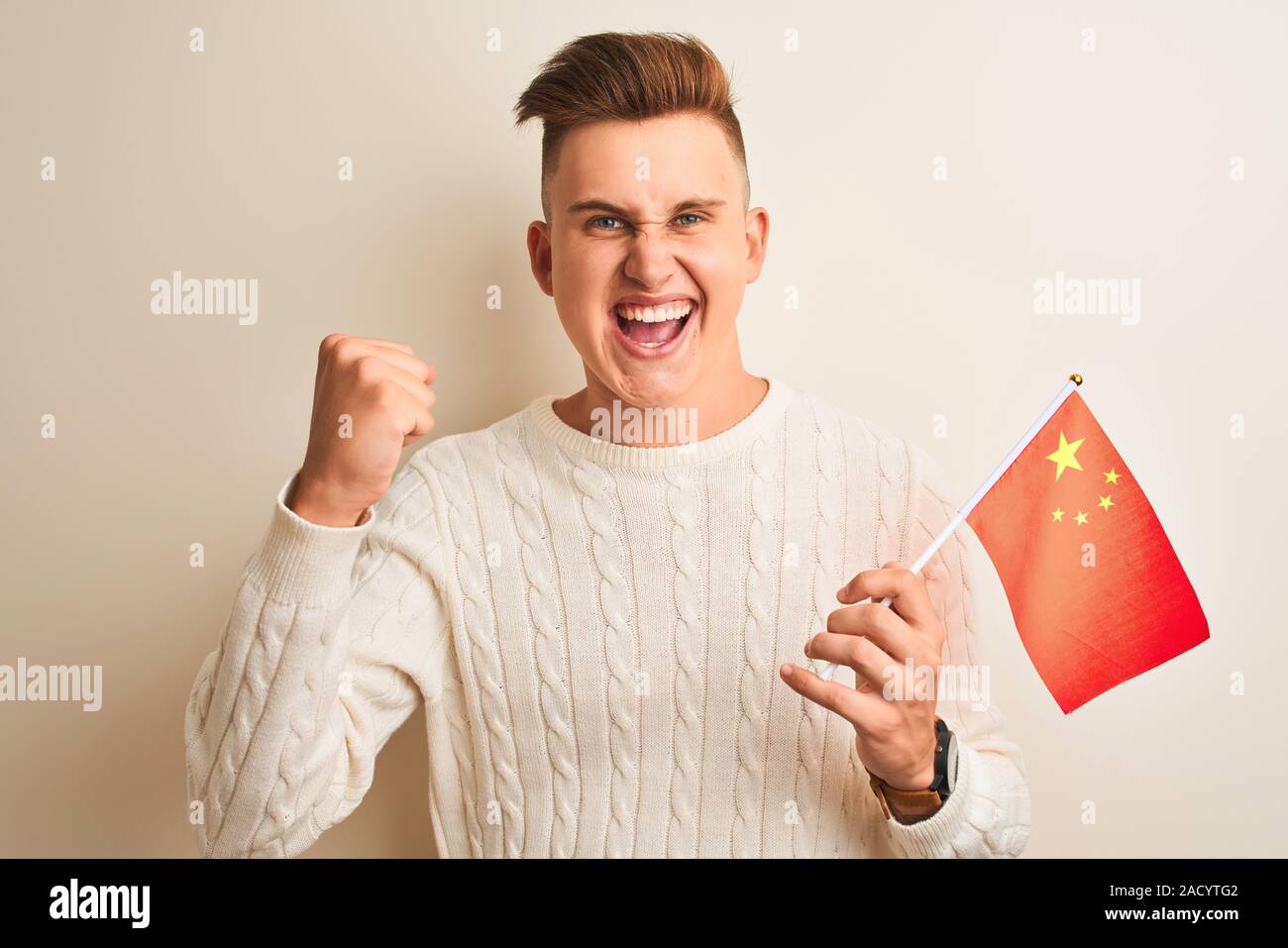 Young handsome man holding Chinese China flag over isolated white ...