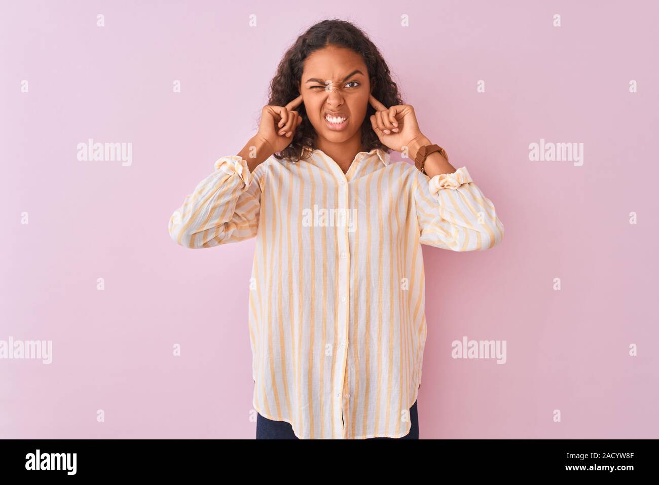 Young Brazilian Woman Wearing Striped Shirt Standing Over Isolated Pink