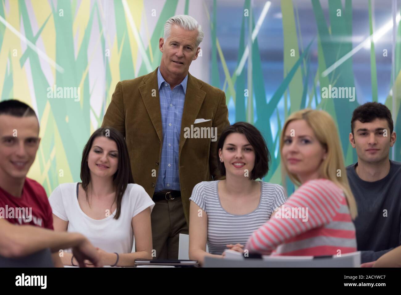 portrait of teacher with students group in background Stock Photo - Alamy