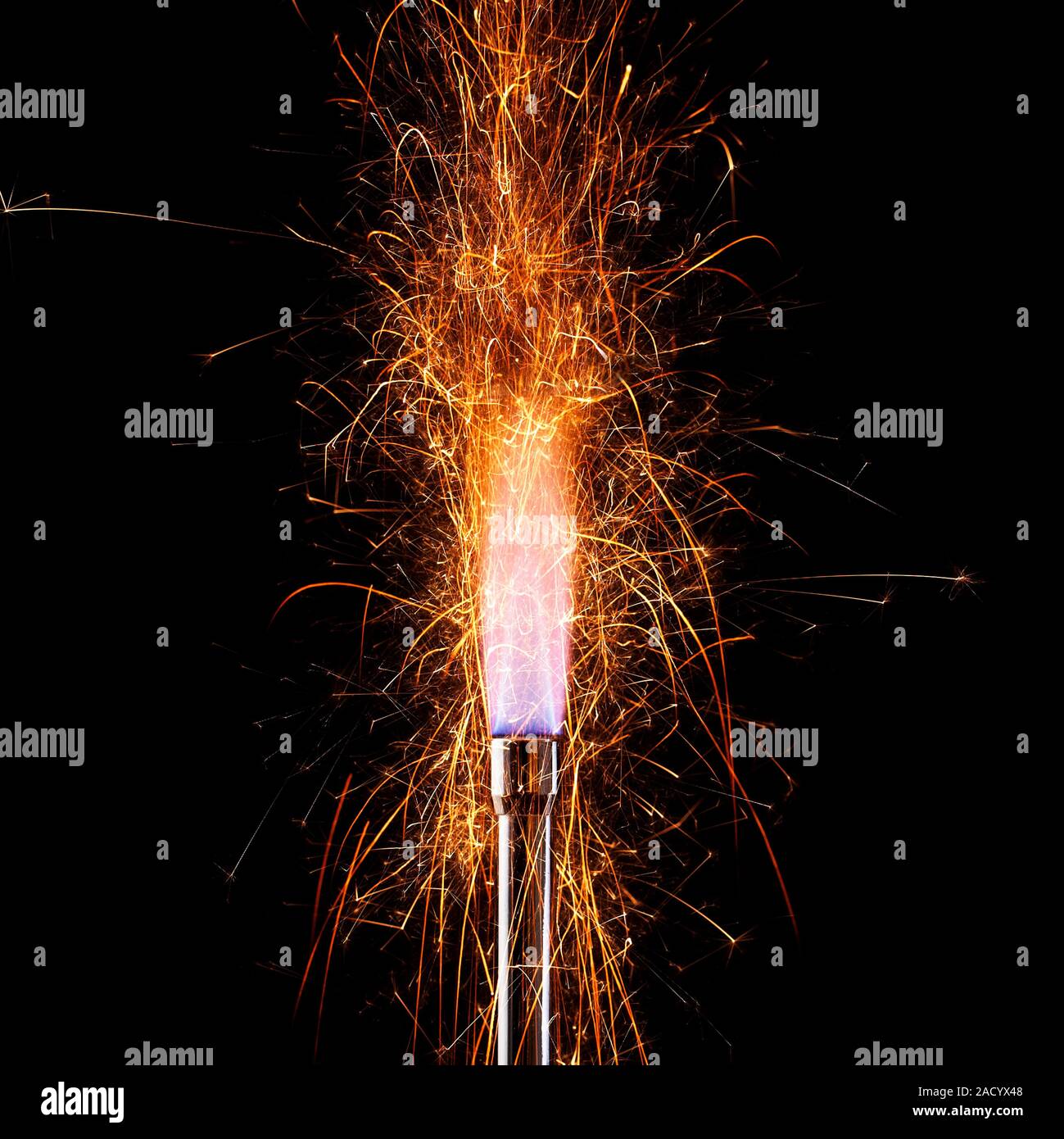 Iron filings burning in a gas flame in air. Iron filings dropped into a ...