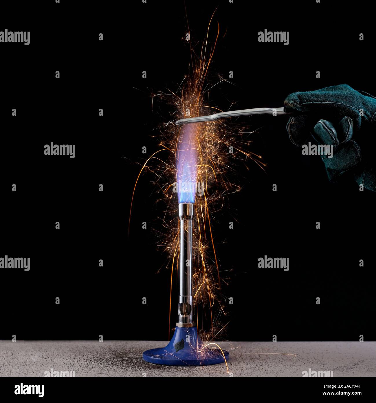 Iron filings burning in a gas flame in air. Iron filings dropped into a ...