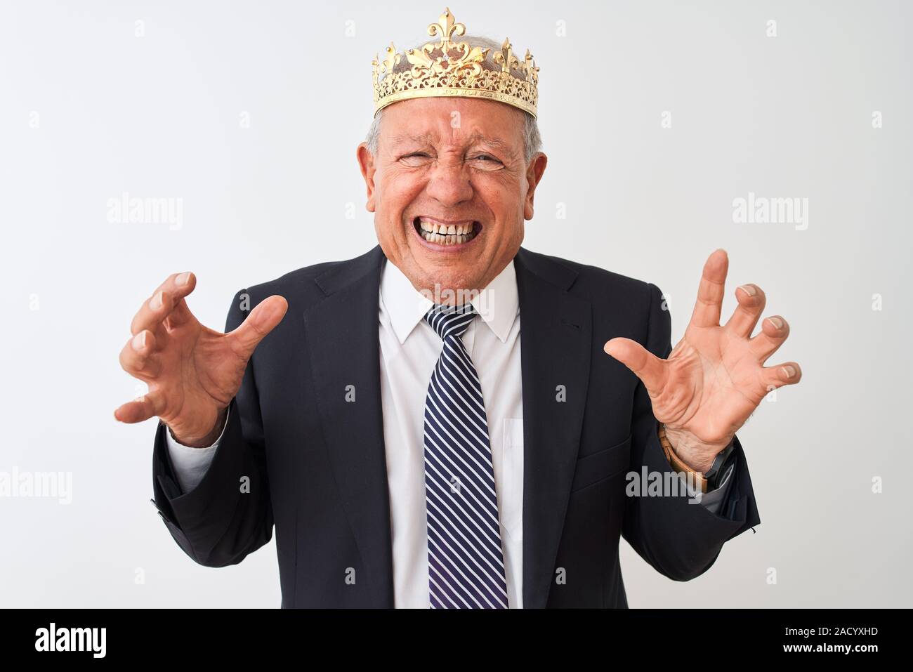 Senior grey-haired businessman wearing crown king over isolated white ...