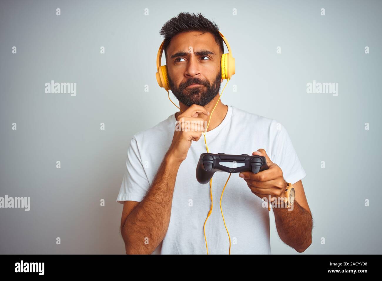 Arab indian gamer man playing video game using headphones over isolated ...
