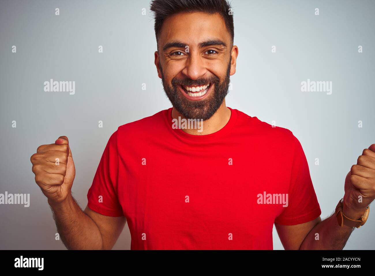 Young indian man wearing red t-shirt over isolated white background ...