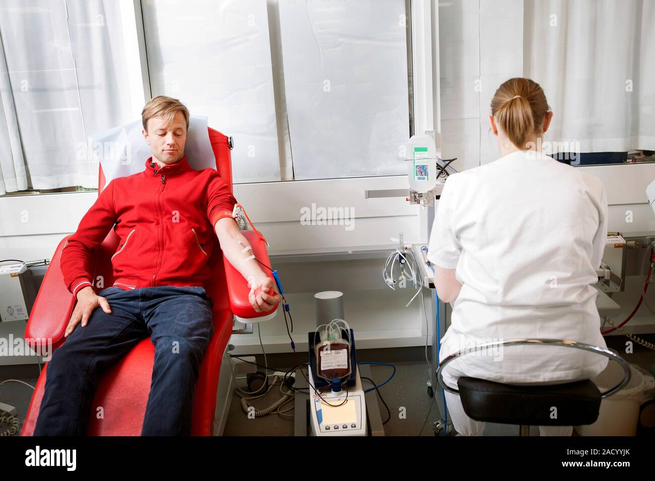 Blood donation clinic. Nurse with a man giving blood in a blood ...