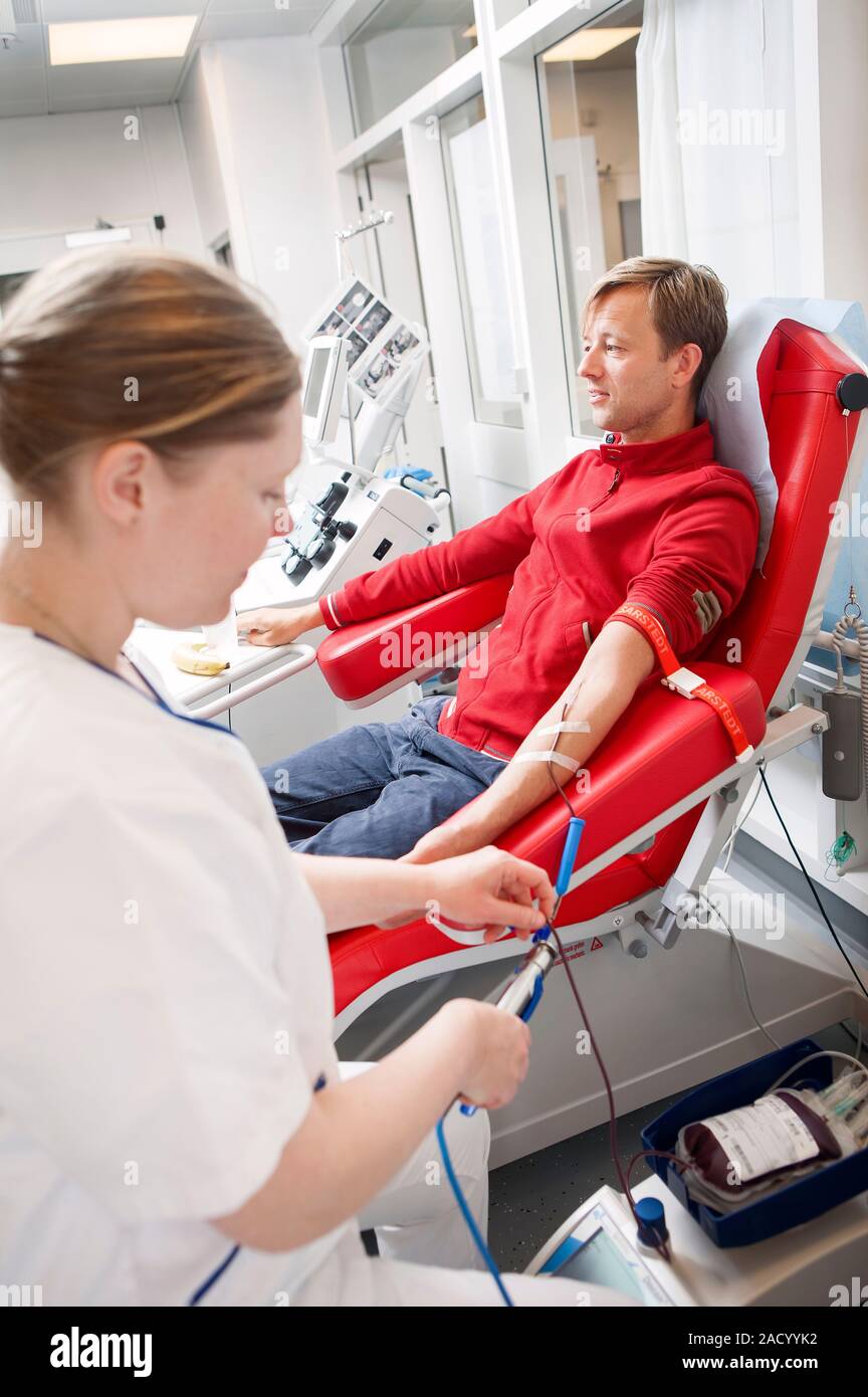 Blood donation clinic. Nurse with a man giving blood in a blood ...