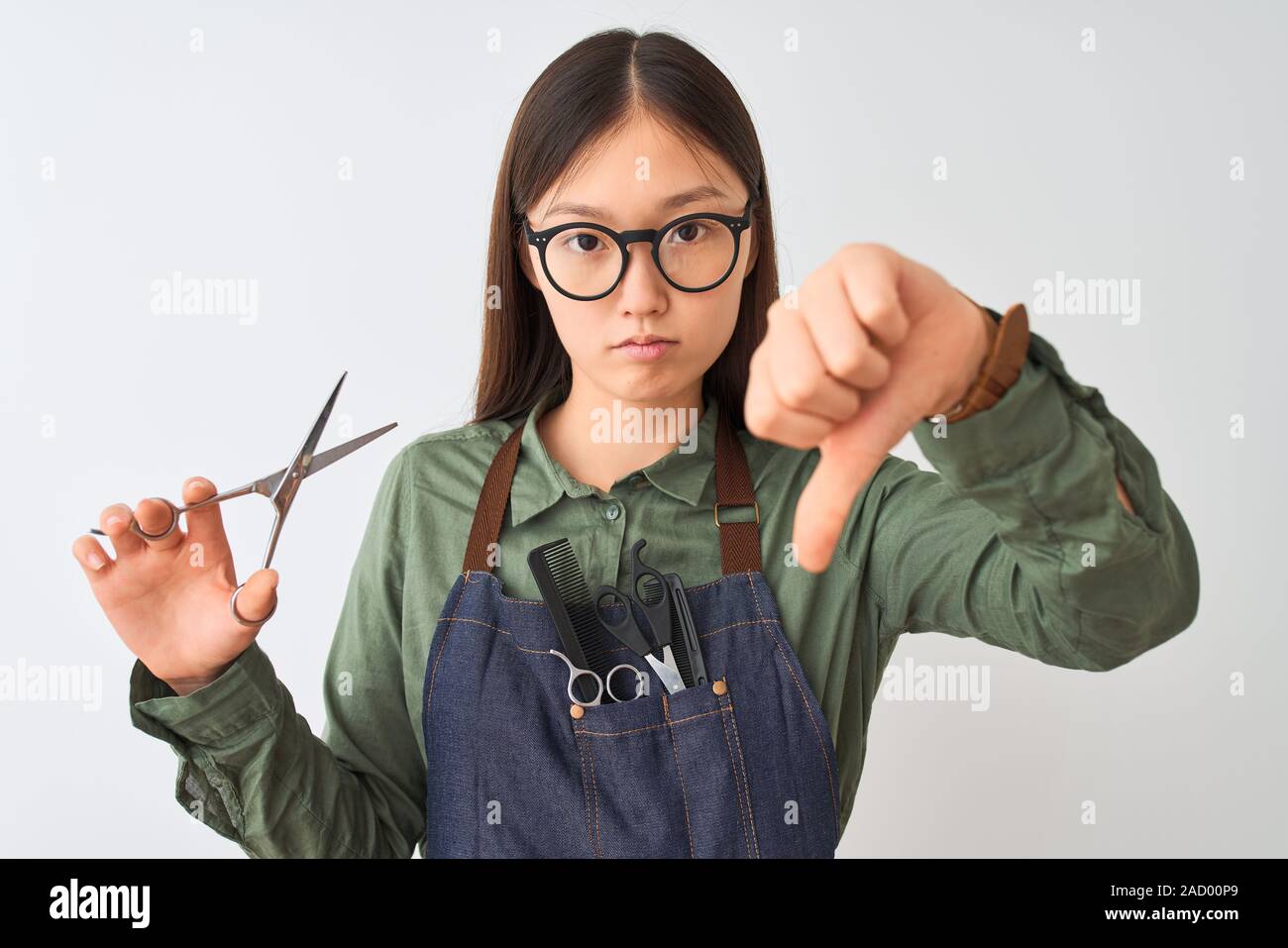 Chinese hairdresser woman wearing glasses holding scissors over ...