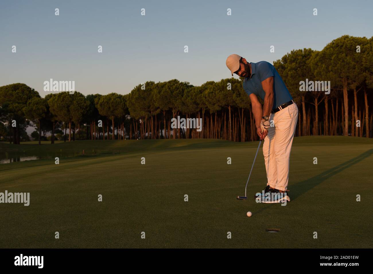 golfer hitting shot at golf course Stock Photo - Alamy