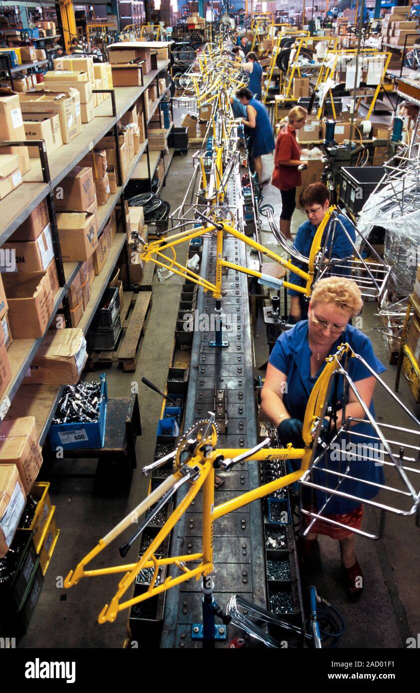 Bike production. Workers in a bicycle factory handling production on a ...