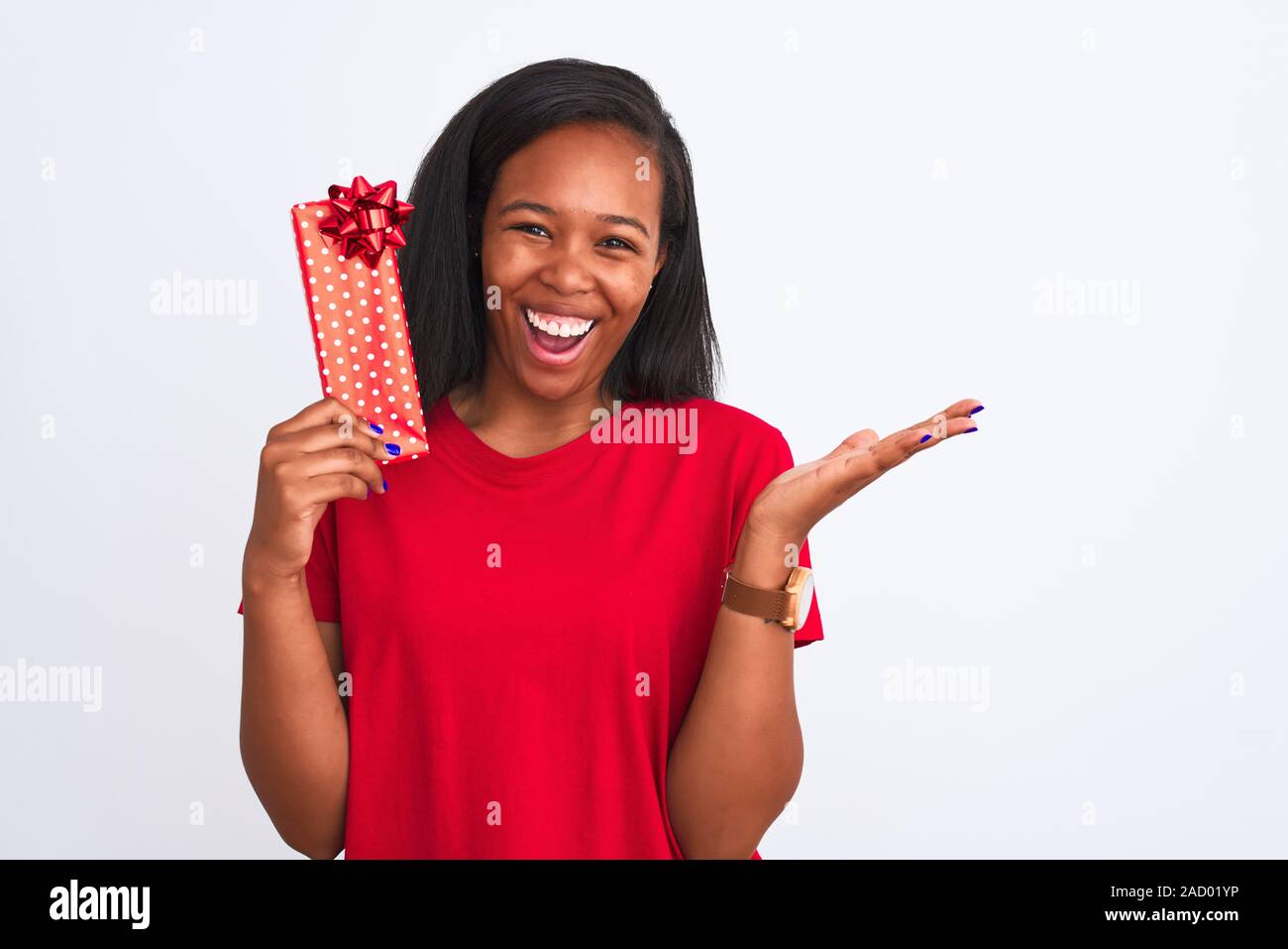 Young african american woman holding birthday present over isolated ...