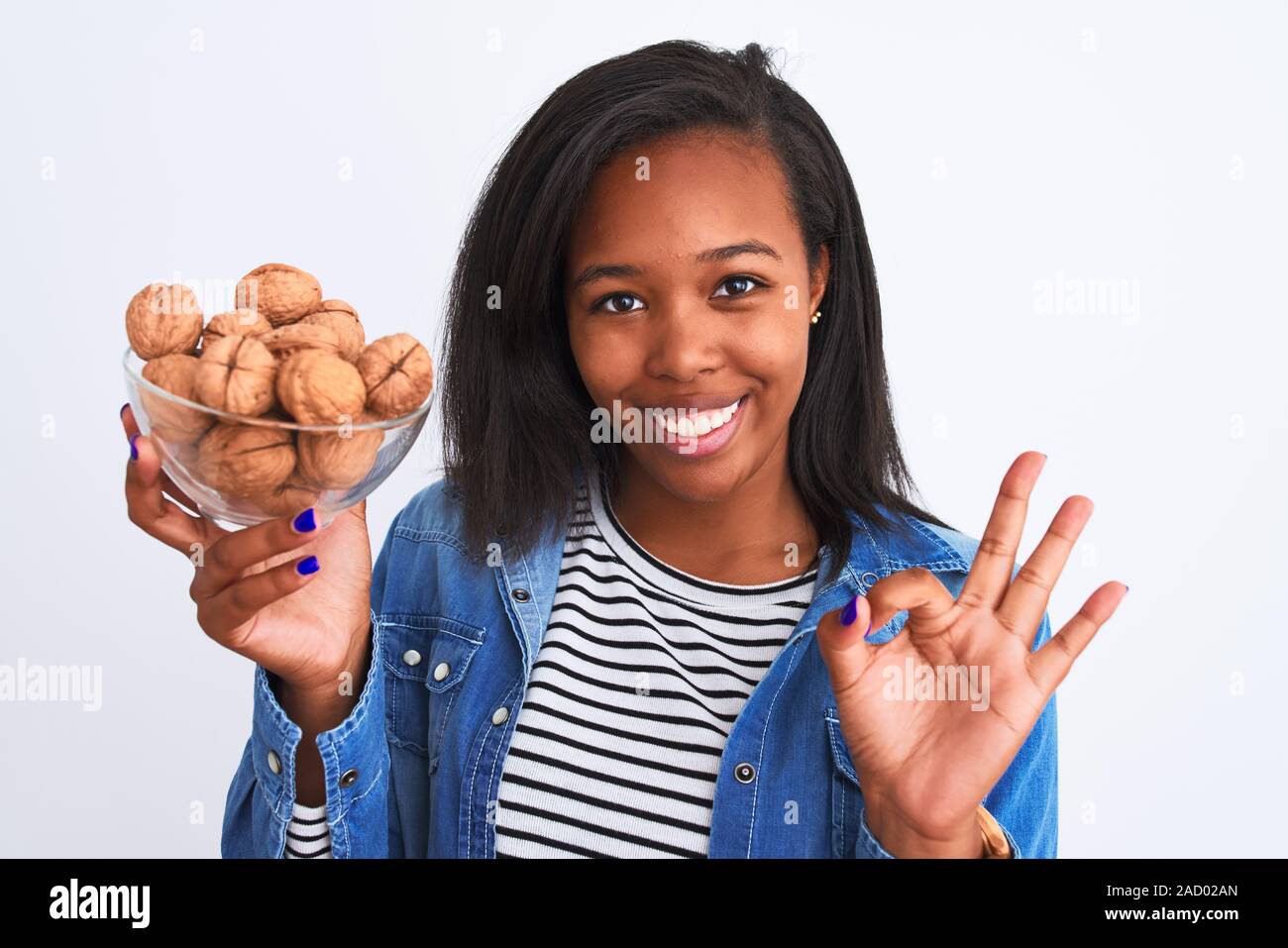 Young african american woman holding bunch of walnuts over isolated ...