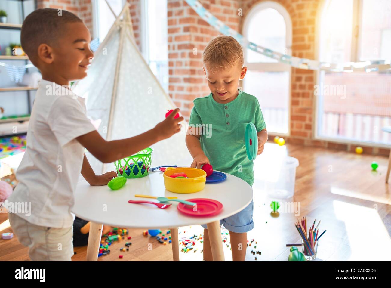 Adorable toddlers playing around lots of toys at kindergarten Stock ...