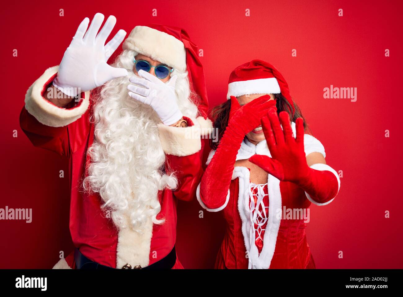 Middle age couple wearing Santa costume and sunglasses over isolated ...