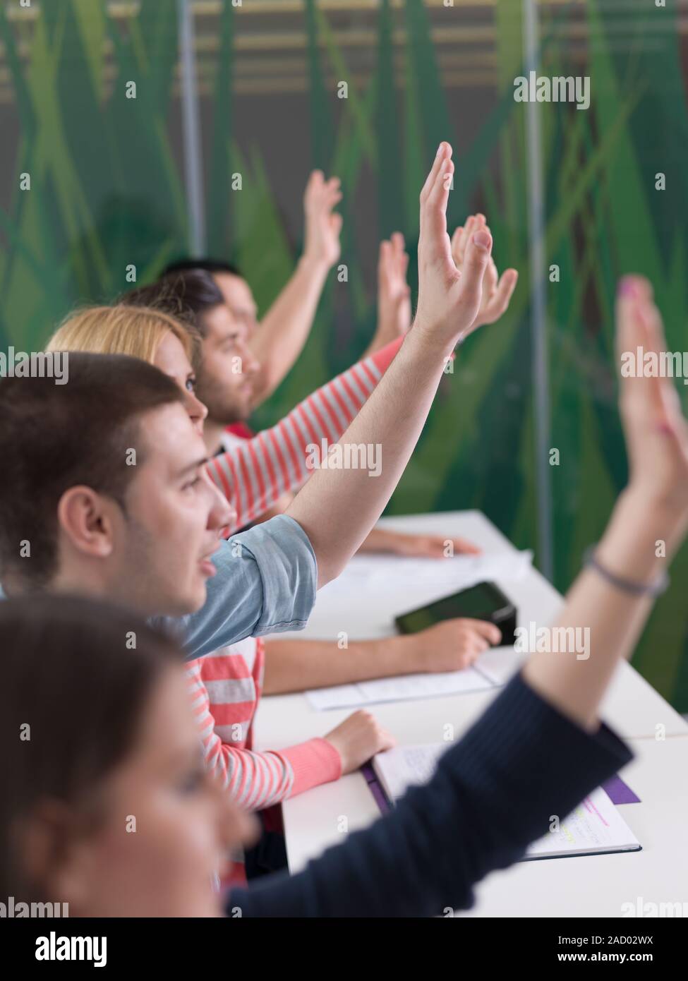students group raise hands up on class Stock Photo - Alamy