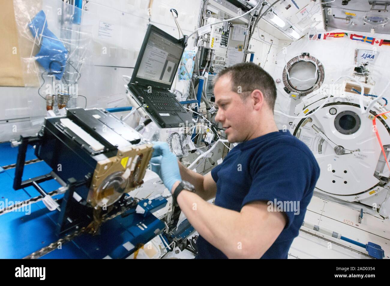 Astronaut cleaning ISS lab equipment. Expedition 35 flight engineer Tom ...
