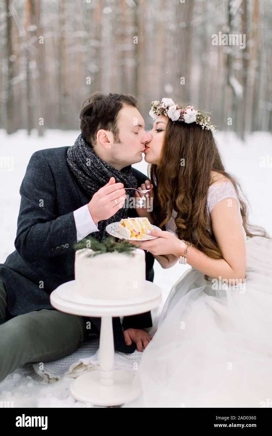 Stylish pretty bride and groom eating beautiful decorated winter ...