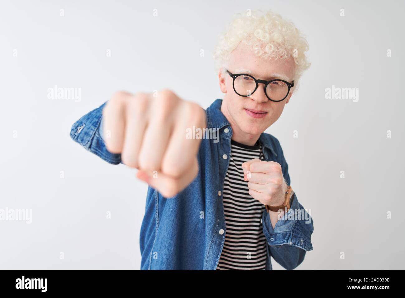 Young albino blond man wearing denim shirt and glasses over isolated ...