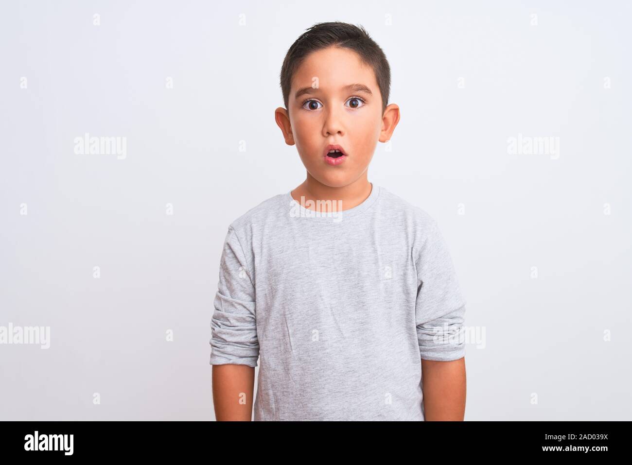 Beautiful kid boy wearing grey casual t-shirt standing over isolated ...