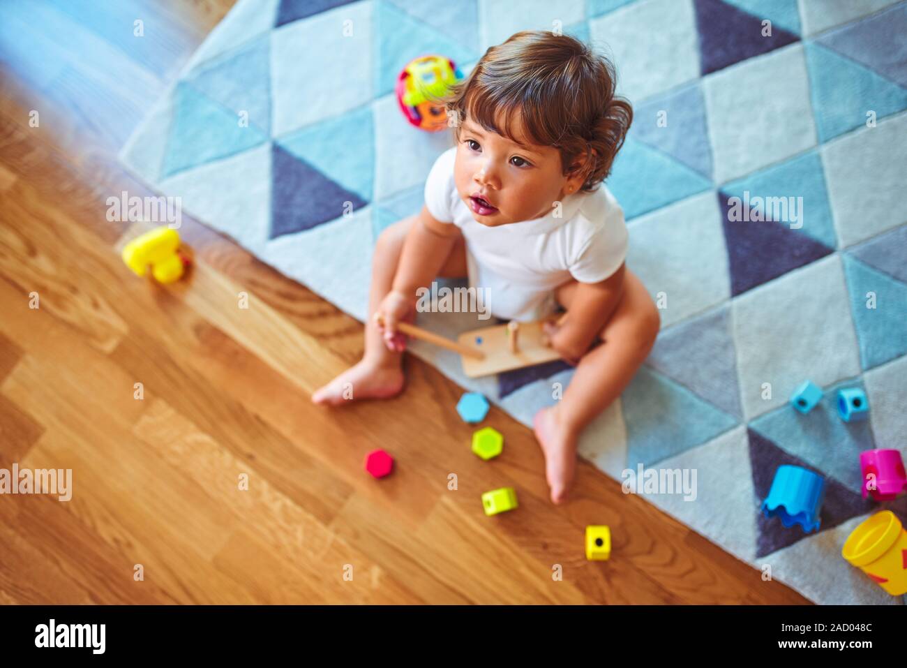 Beautiful toddler child girl playing with toys on the carpet Stock ...