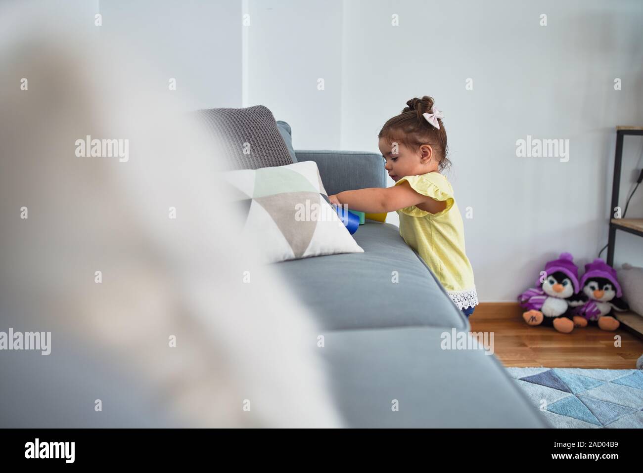 Beautiful toddler standing playing with colorful plastic cups at ...